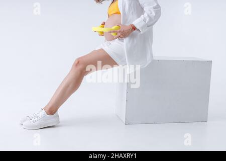 Pregnant woman letting her baby listen to music by placing a set of ...
