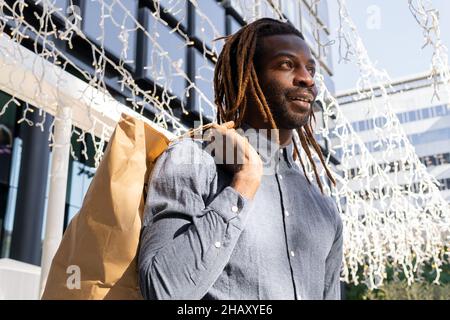 African handsome man holding shopping bags and credit card smiling with ...