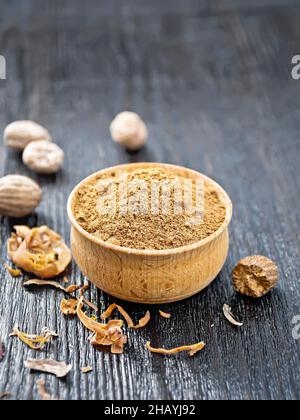 Whole and grated nutmeg in wooden bowl isolated on white background ...