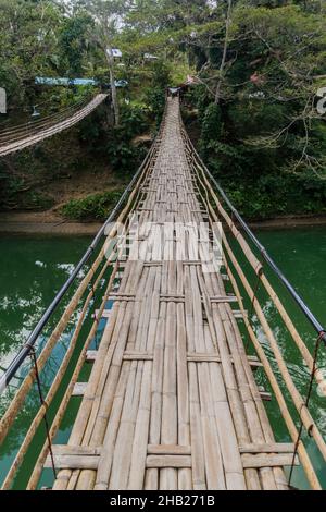 Bamboo pedestrian hanging bridge over river in tropical forest, Bohol ...