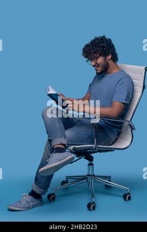 Photo of cute young guy focused look display play gamer computer purple ...