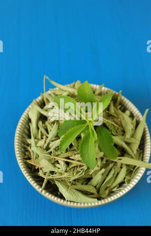 Dried stevia in a round cup and a wooden spoon.Sugar substituteStevia ...