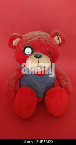 Scary red soft bear toy with one eye in a red background Stock Photo ...
