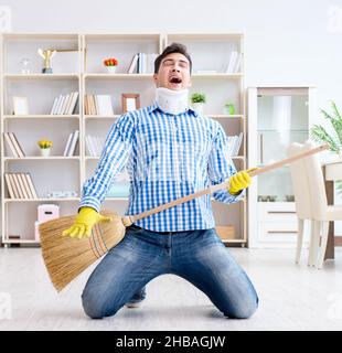 Man with neck unjury cleaning house in housekeeping concept Stock Photo ...
