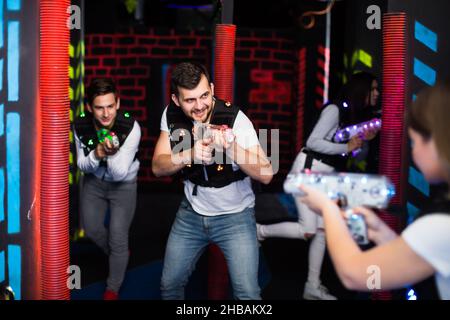 Emotional guy playing laser tag Stock Photo - Alamy