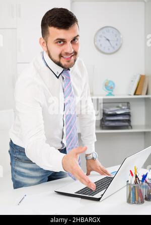 Smiling young employee working effectively on project in office Stock ...