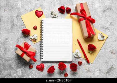Composition with envelopes, card, gifts and rose petals on color ...