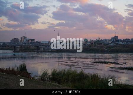 Sunset behind the old bridge over Tigris River in the northern Iraqi ...