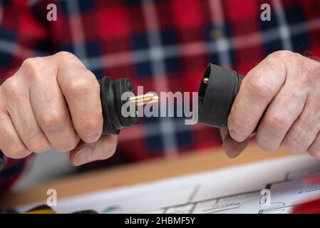 Electrician hands holding electrical plugs; multiple exposure Stock ...