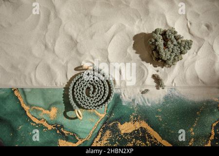 Unrolled moss green yoga mat, rope for stretching and dried moss on ...