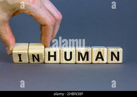 Human or inhuman symbol. Businessman turns wooden cubes and changes the ...