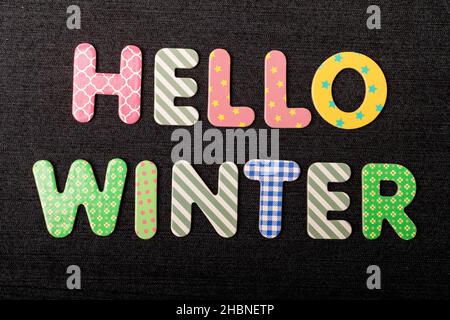 Text HELLO WINTER made of colorful letters and fir branches on blue ...