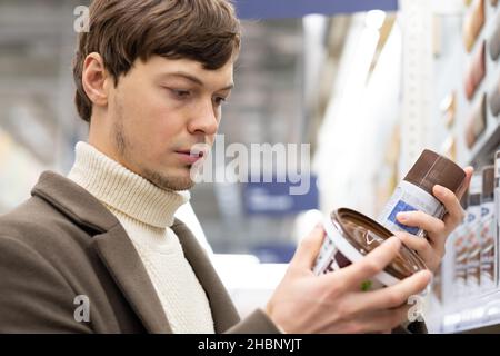 a man in a hardware store chooses a jigsaw Stock Photo - Alamy