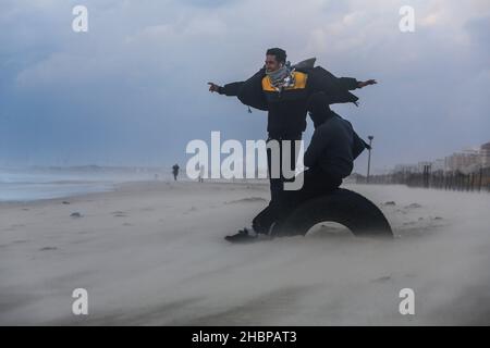 Palestinians seen on the seashore during the sunset and a dust storm ...