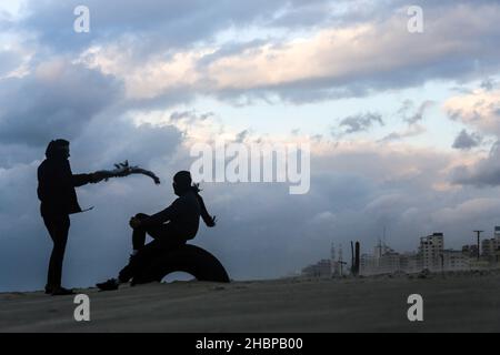 Palestinians seen on the seashore during the sunset and a dust storm ...