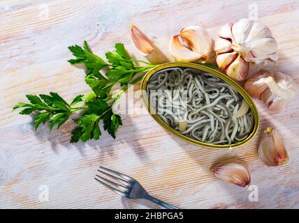 Pickled eels on background with garlic and greens at table Stock Photo ...