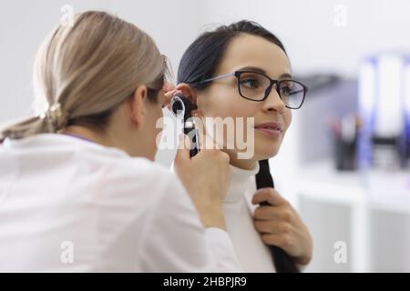Doctor check patients ear on medical examination with special tool ...