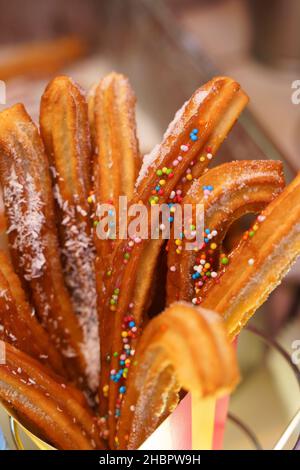 Churros waffles in hand on the street. Churros street food dessert made ...