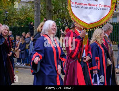 Men and women in ceremonial livery robes, holding a communicators sign ...