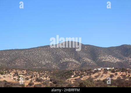 A landscape of a deserted area with poor vegetation under the blue ...