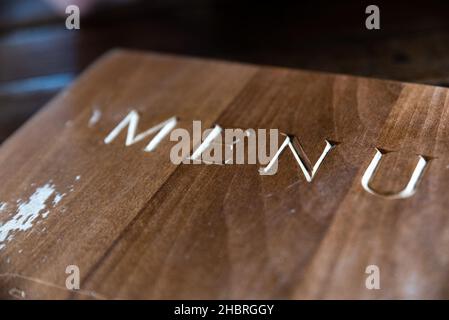 Wooden cover of the menu card with the inscription. Scratched and ...