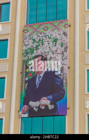 A portrait of Tajik President Emomali Rahmon hangs over a swimming pool ...
