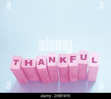 Wooden cubes with word Thankful on a light blue background. Thank you ...