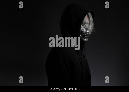 The horror man with skull mask standing in the dark Stock Photo - Alamy