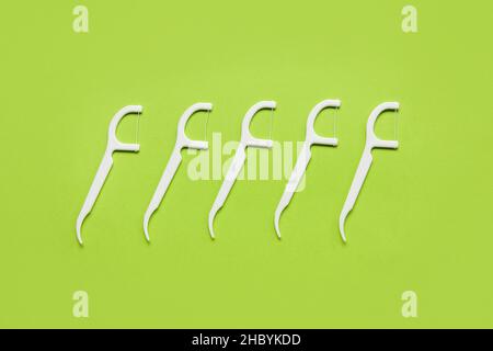 Dental floss, toothpicks, brush and green crocodile on white background ...