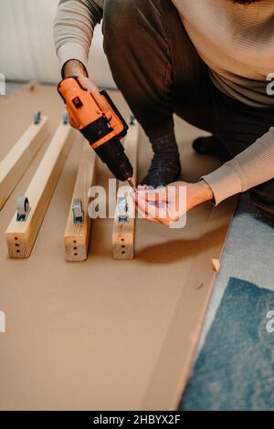 Man assembling sofa furniture at home Stock Photo - Alamy