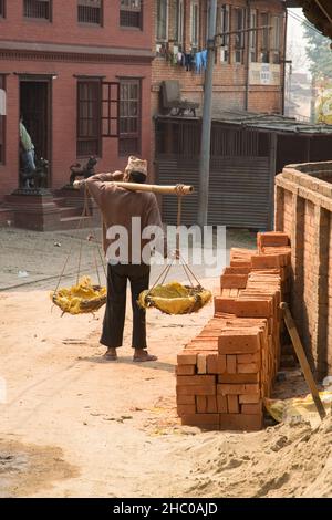 man carrying bricks in nepal Stock Photo - Alamy