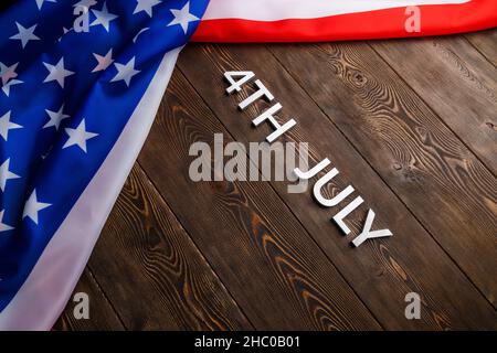 the words 4th july and crumpled usa flag on flat textured wooden ...