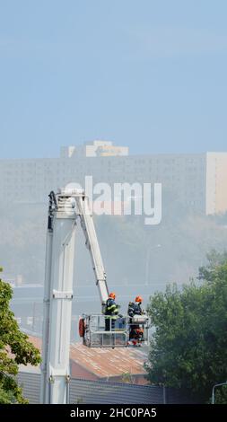 View of firefighters using platform truck to extinguish fire from ...