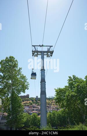 funicular road with a cabin on a background of blue sky and green trees ...