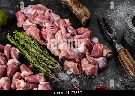 Raw uncooked chicken gizzards set, on black wooden table background ...