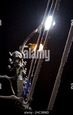 Snowfall and snow on wires under a street lamp at night Stock Photo - Alamy