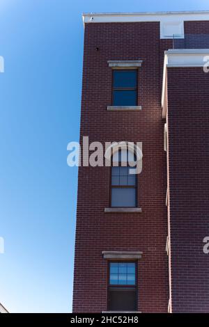 Vertical shot of a tall brick building with a one open window Stock ...