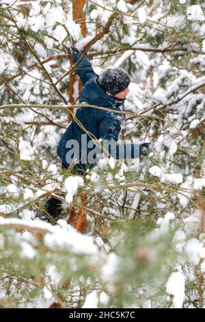 Defocus smiling child boy in winter forest in snowstorm. Smiling kid ...