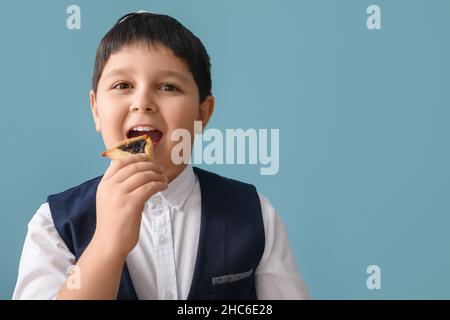 Little Jewish boy with tasty Hamantaschen for Purim holiday on white ...