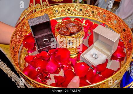 Round gold tray of traditional Arabic sweets and pastries carried by a ...