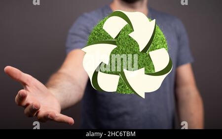 Male's hand holding an illustration of a recycling sign Stock Photo - Alamy