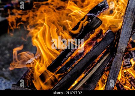 A large fire made of planks. Firewood in a bright flame. Firewood burns ...