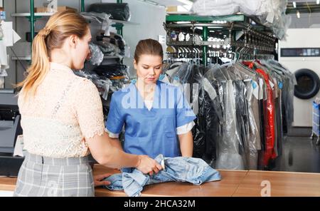 Worker checking clothes in dry cleaner Stock Photo - Alamy