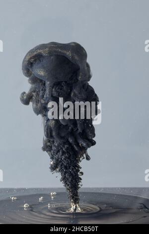 Explosion of colored, fluid and neoned liquids on black studio ...