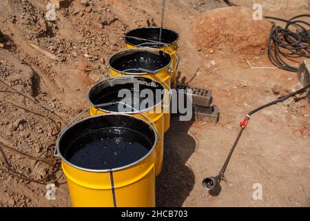 Bitumen mastic in buckets. Protective bitumen mastic for concrete ...