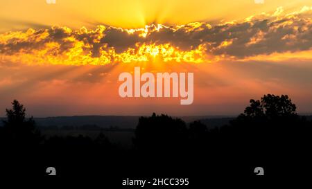 Crimson sunrise (sunset) bright rays of the sun breaking through the ...