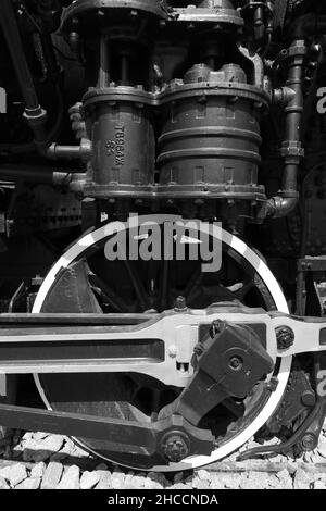 A grayscale of an old and historic steam train on track in a museum ...