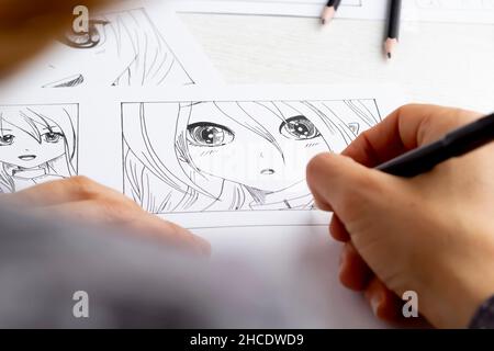Manga style. The artist draws anime comics on paper. The illustrator ...