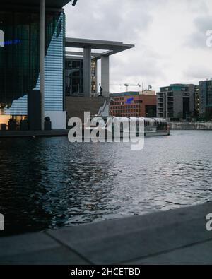 A vertical shot of the river with a boat surrounded by green cliffs ...