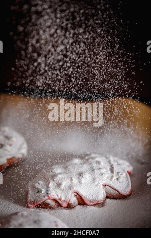 Sprinkle icing sugar over the Christmas cookies Stock Photo - Alamy